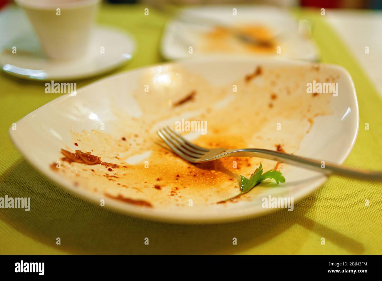 Empty and dirty plate with a fork and bits of food after lunch on the ...