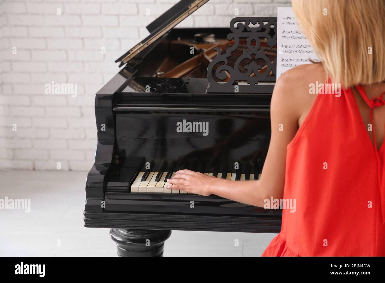 Talented woman playing piano indoors Stock Photo - Alamy