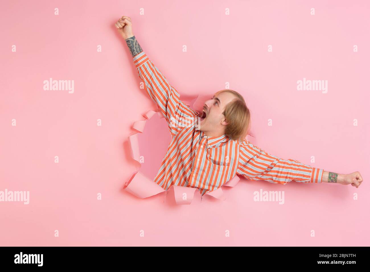 Crazy winner, celebrating. Cheerful caucasian young man poses in torn ...