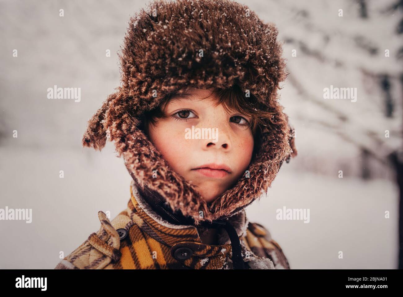 Portrait of a boy wearing a hunters cap in the snow, USA Stock Photo ...