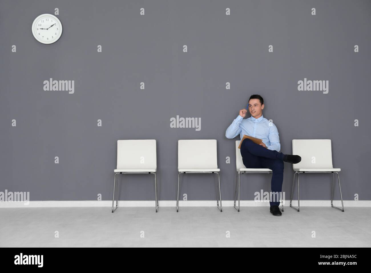 Young man waiting for job interview in hall Stock Photo - Alamy
