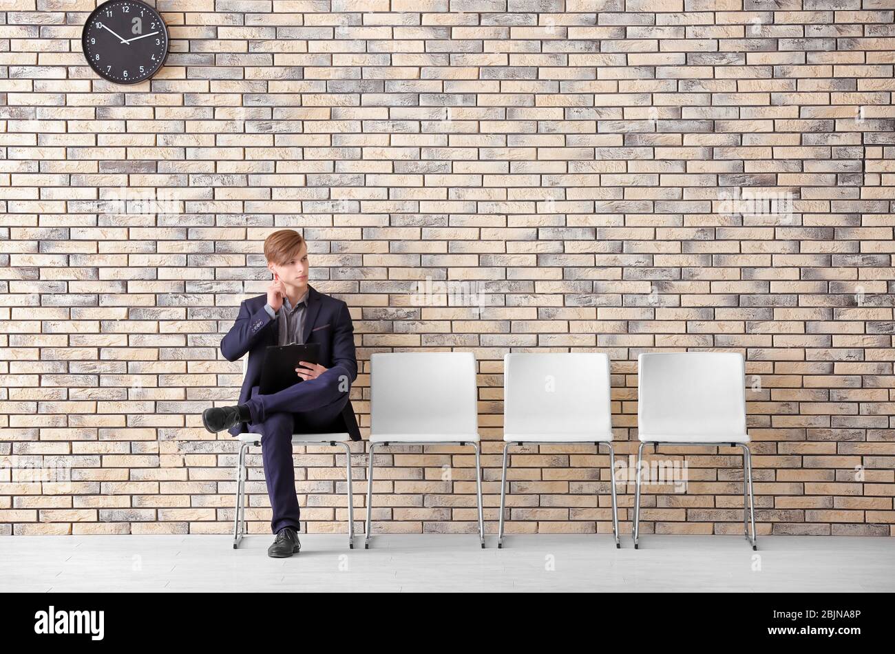 Young man waiting for job interview in hall Stock Photo - Alamy