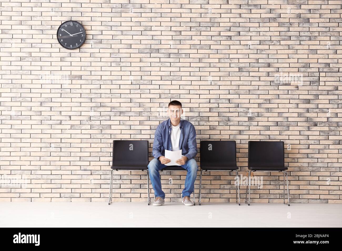 Young man waiting for job interview in hall Stock Photo - Alamy