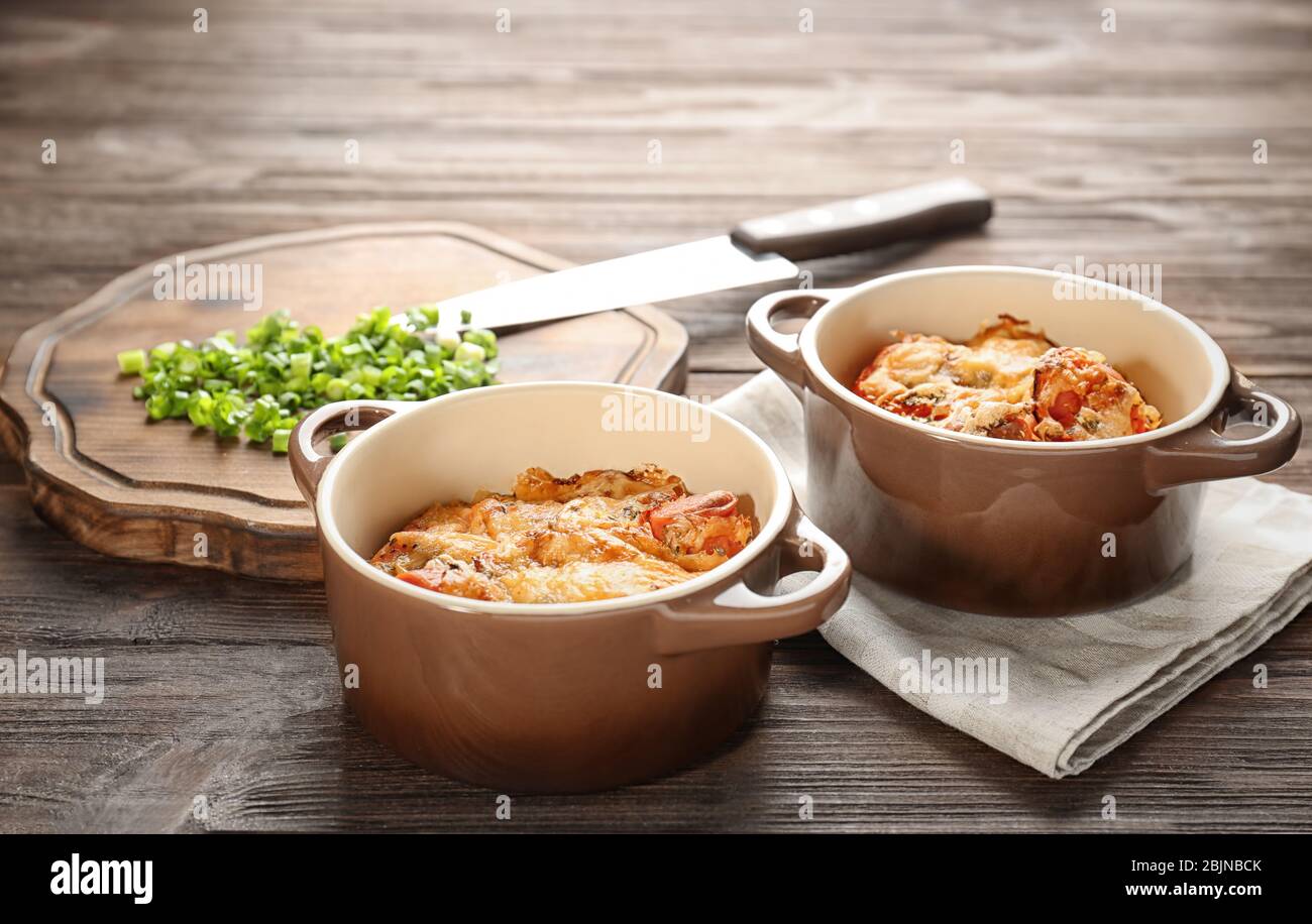 Cocottes with delicious sausage casserole on table Stock Photo - Alamy