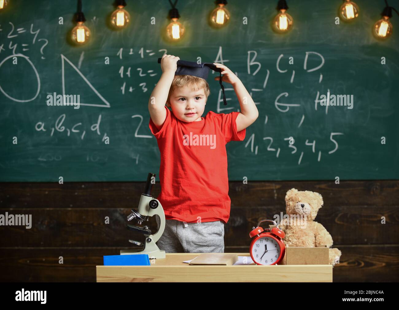 Child, pupil on smiling face near microscope. First former interested ...