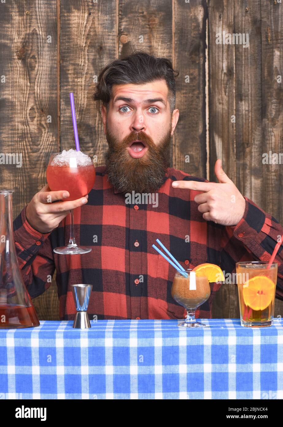 Man points at cocktail on wooden texture background. Hipster prepared ...