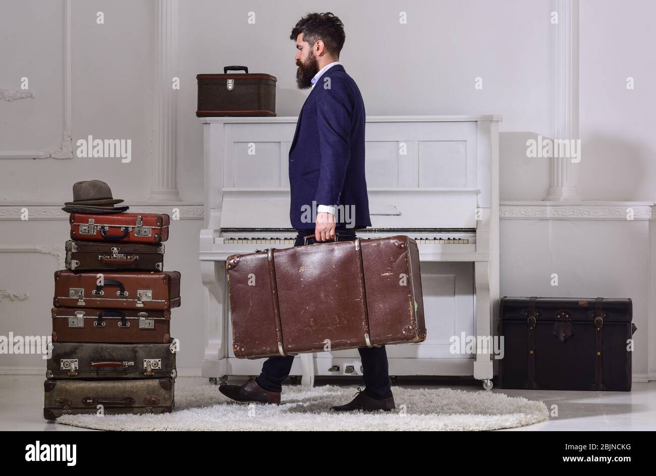 Macho stylish on strict face walks and carries big vintage suitcase ...