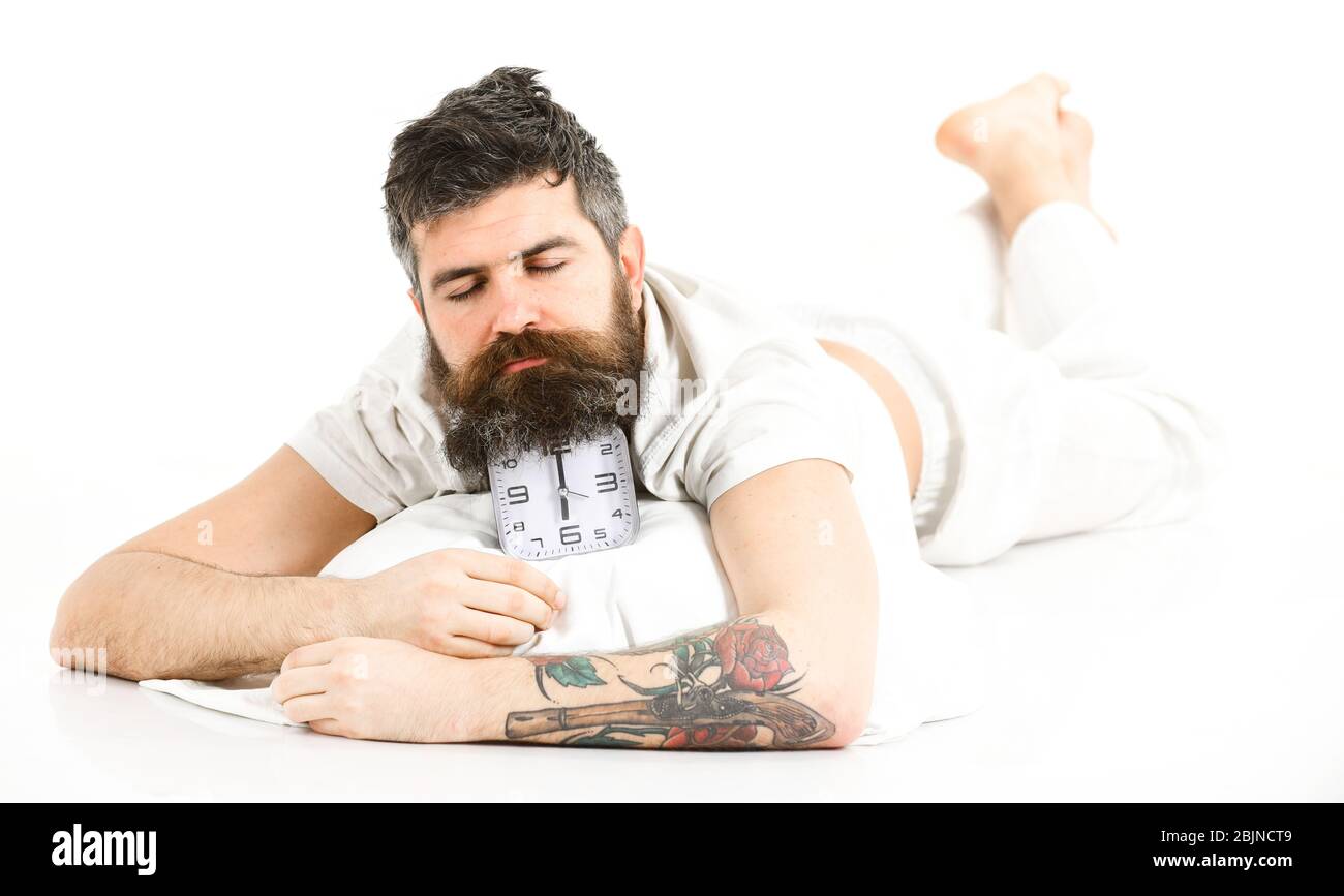 Very deep sleep concept. Guy with sleepy face lies on alarm clock. Man ...