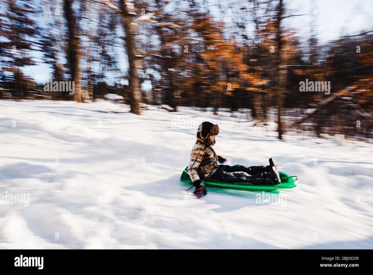 Boy sledding down a hill in the snow, USA Stock Photo - Alamy