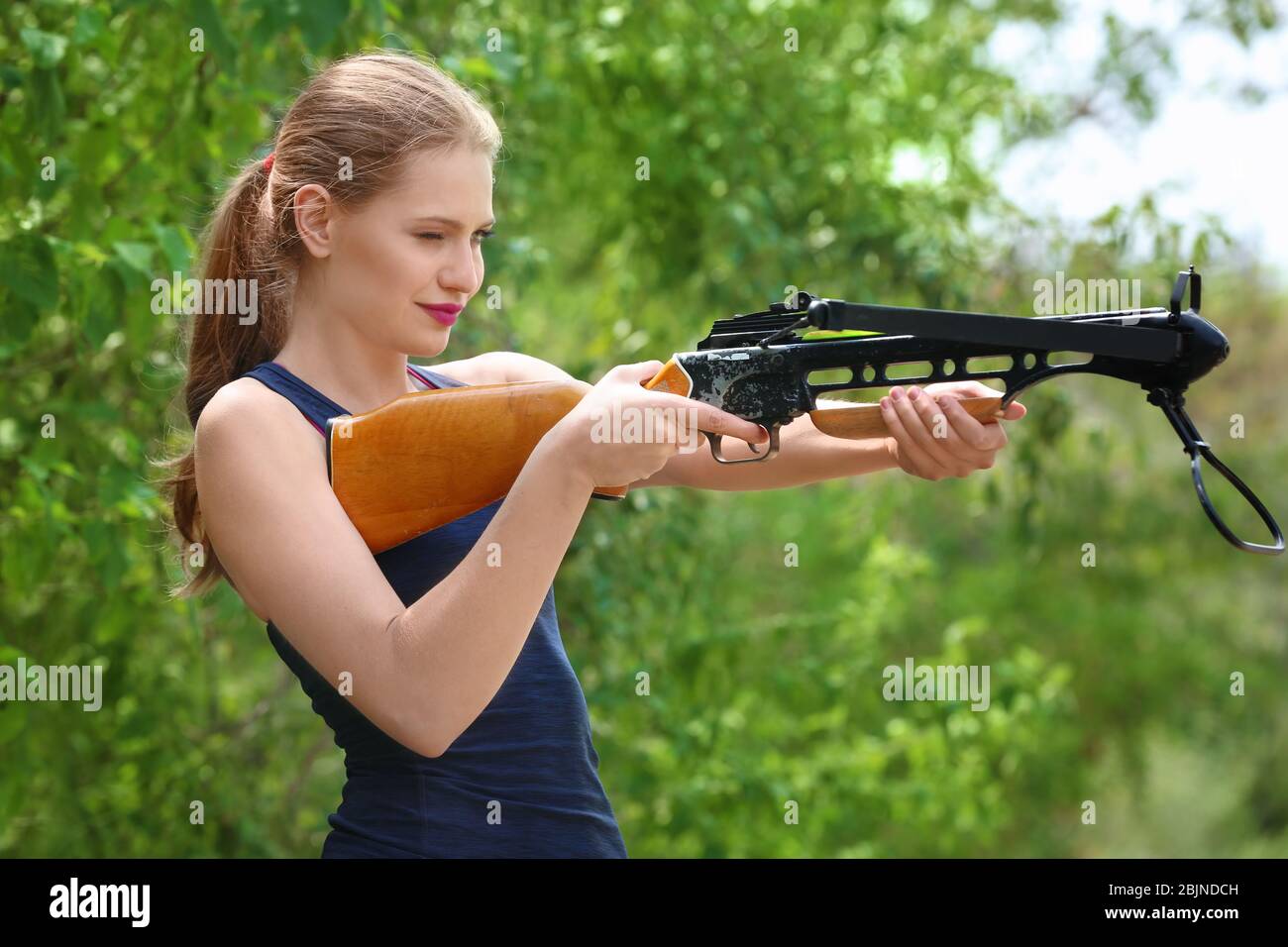 Young woman shooting crossbow outdoors Stock Photo - Alamy
