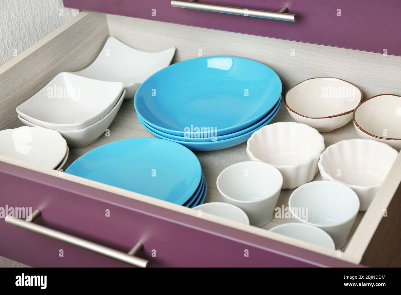Ceramic dishware in kitchen drawer Stock Photo - Alamy