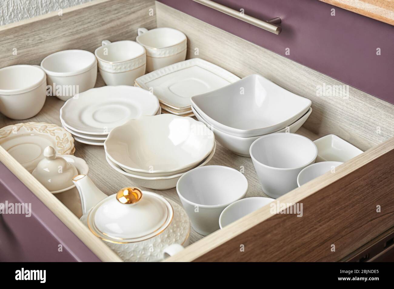 Ceramic dishware in kitchen drawer Stock Photo - Alamy