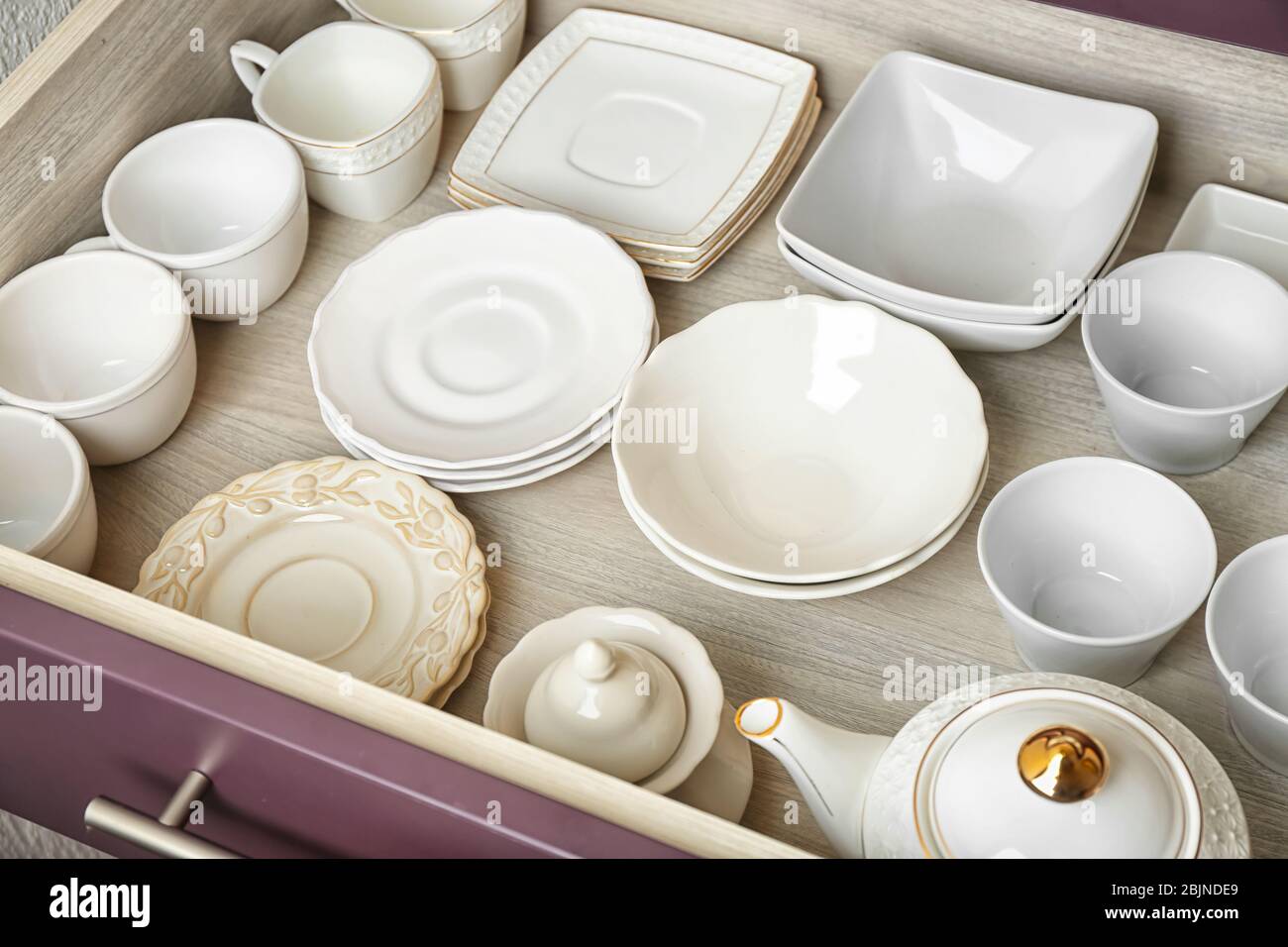 Ceramic dishware in kitchen drawer Stock Photo - Alamy