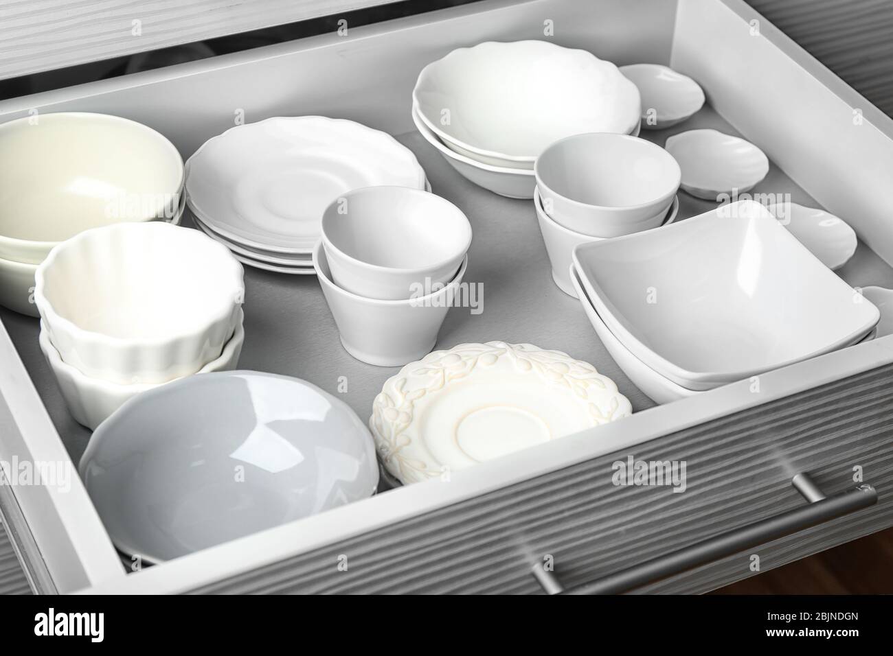Ceramic dishware in kitchen drawer Stock Photo - Alamy