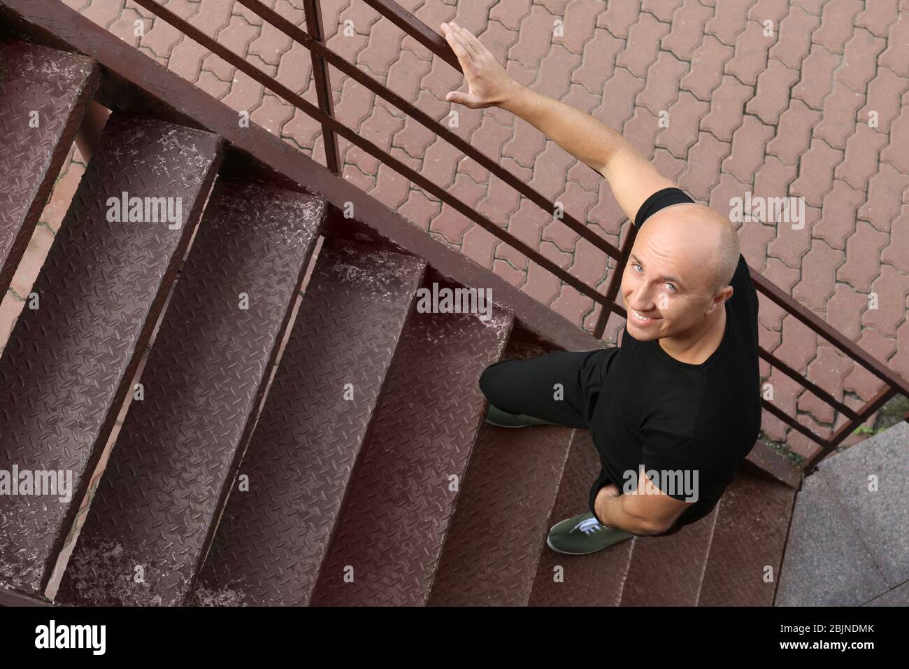 Bald man walking up stairs outdoors Stock Photo - Alamy