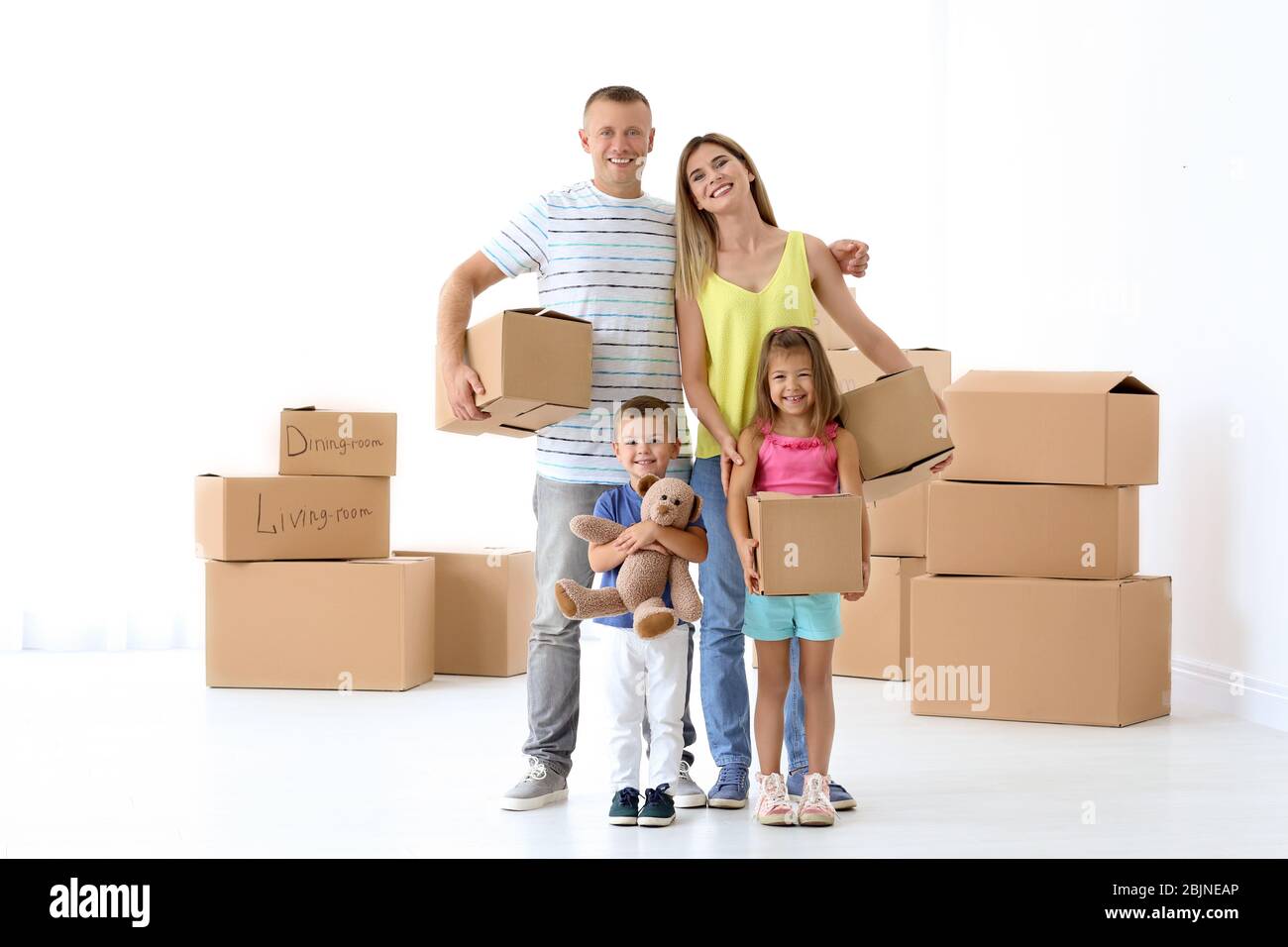 Family with cardboard boxes at new home Stock Photo - Alamy