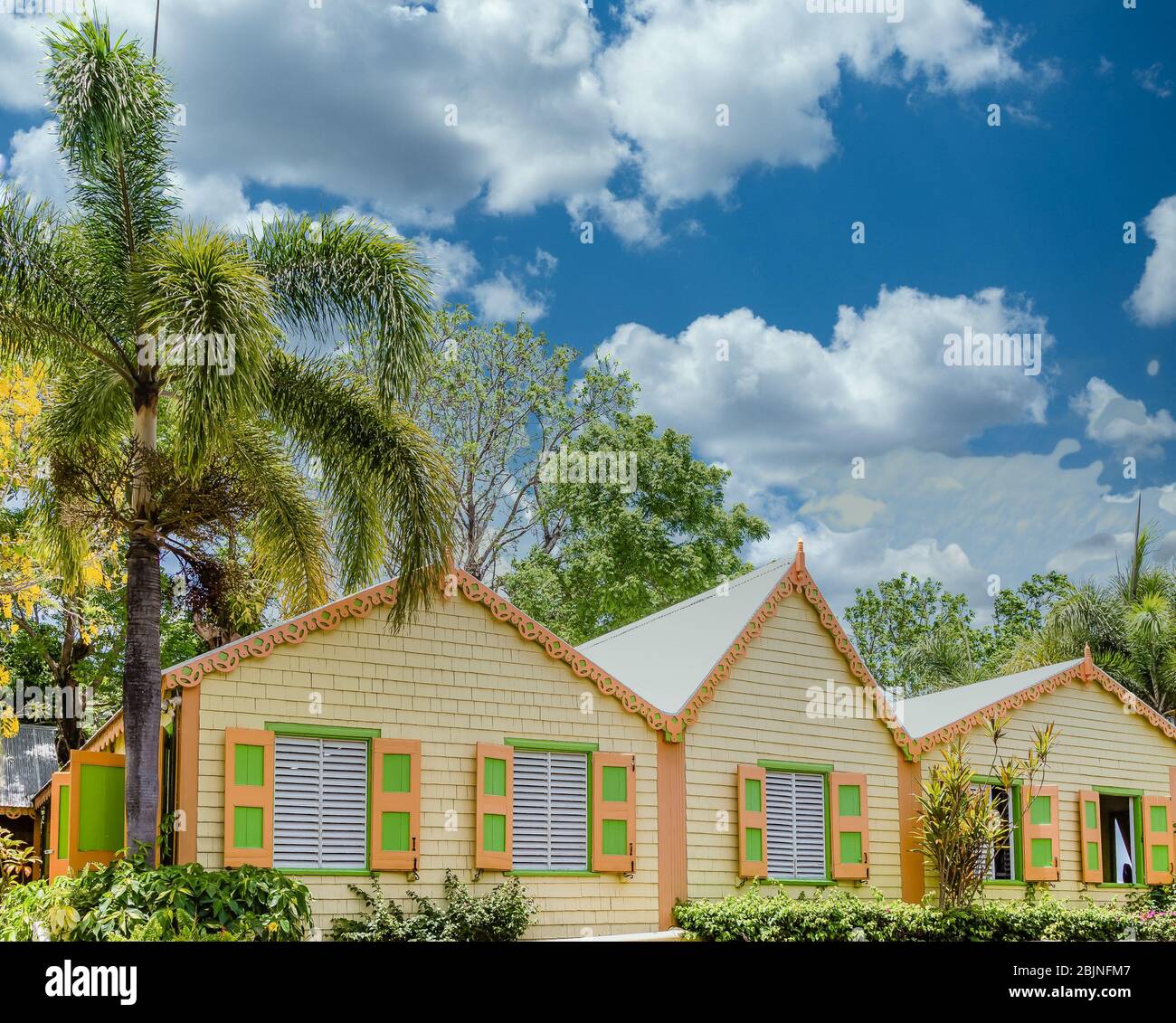Yellow Tropical Bungalows Under Palm Trees Stock Photo - Alamy