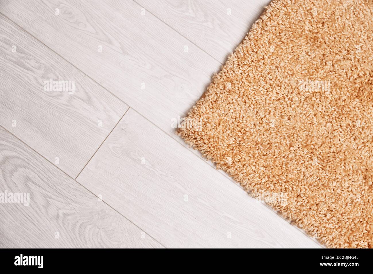 Color soft carpet on wooden floor, closeup Stock Photo - Alamy