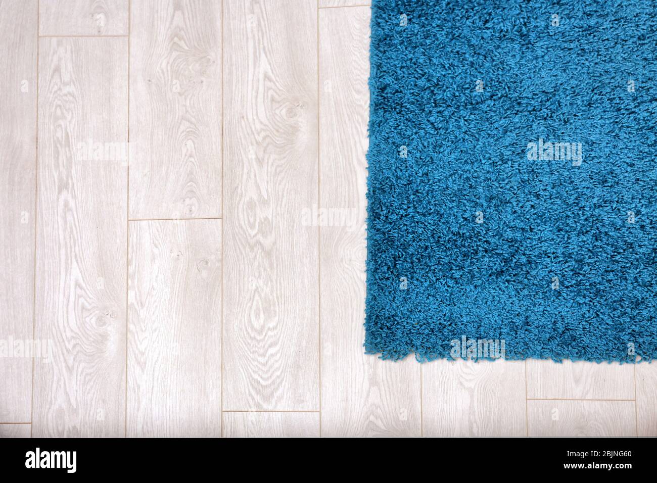 Beautiful blue carpet on wooden floor Stock Photo - Alamy
