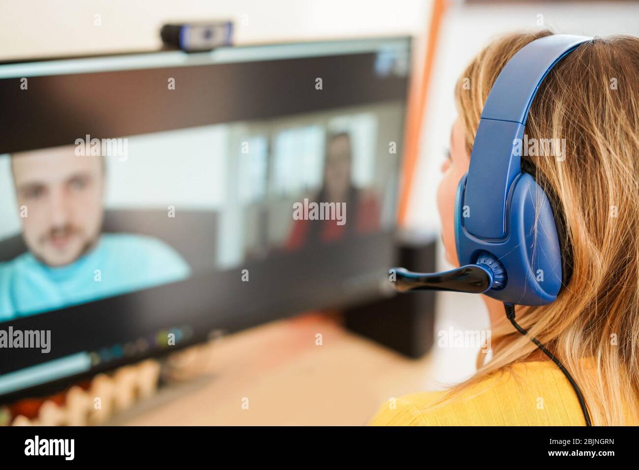 Young woman having a discussion meeting in video call with her team ...