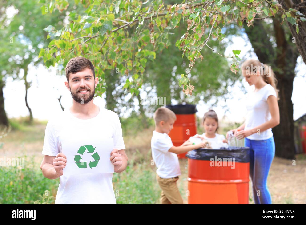 Family throwing garbage into litter bin outdoors. Recycling concept ...