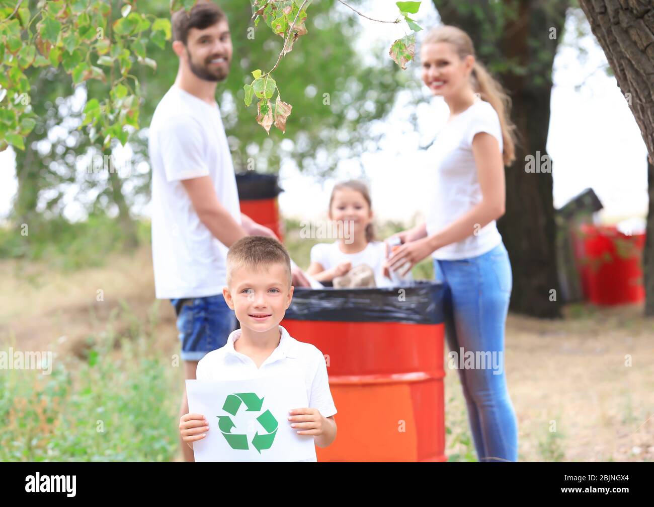Family throwing garbage into litter bin outdoors. Recycling concept ...