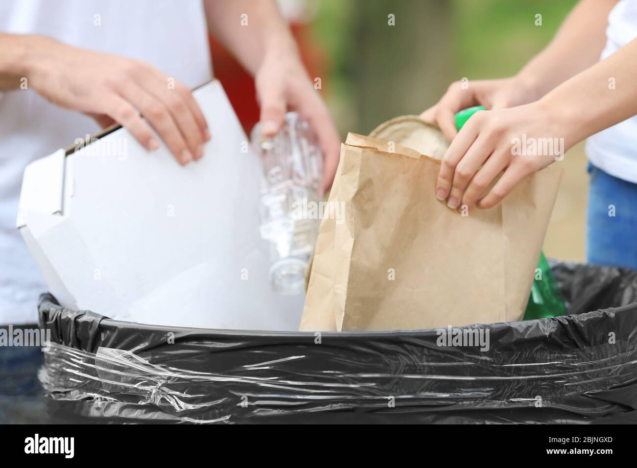 Young couple throwing garbage into litter bin outdoors, closeup Stock ...