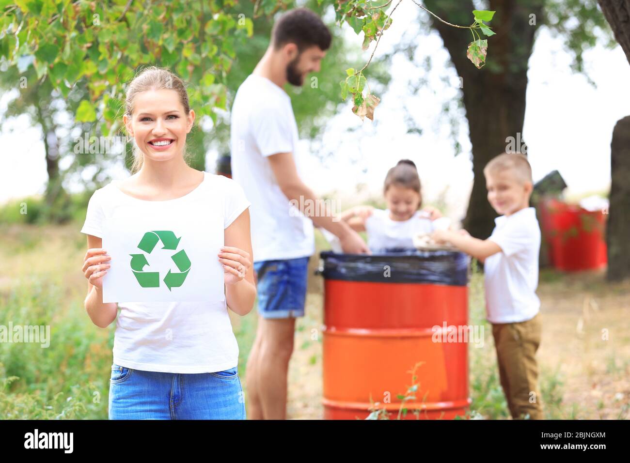 Family throwing garbage into litter bin outdoors. Recycling concept ...