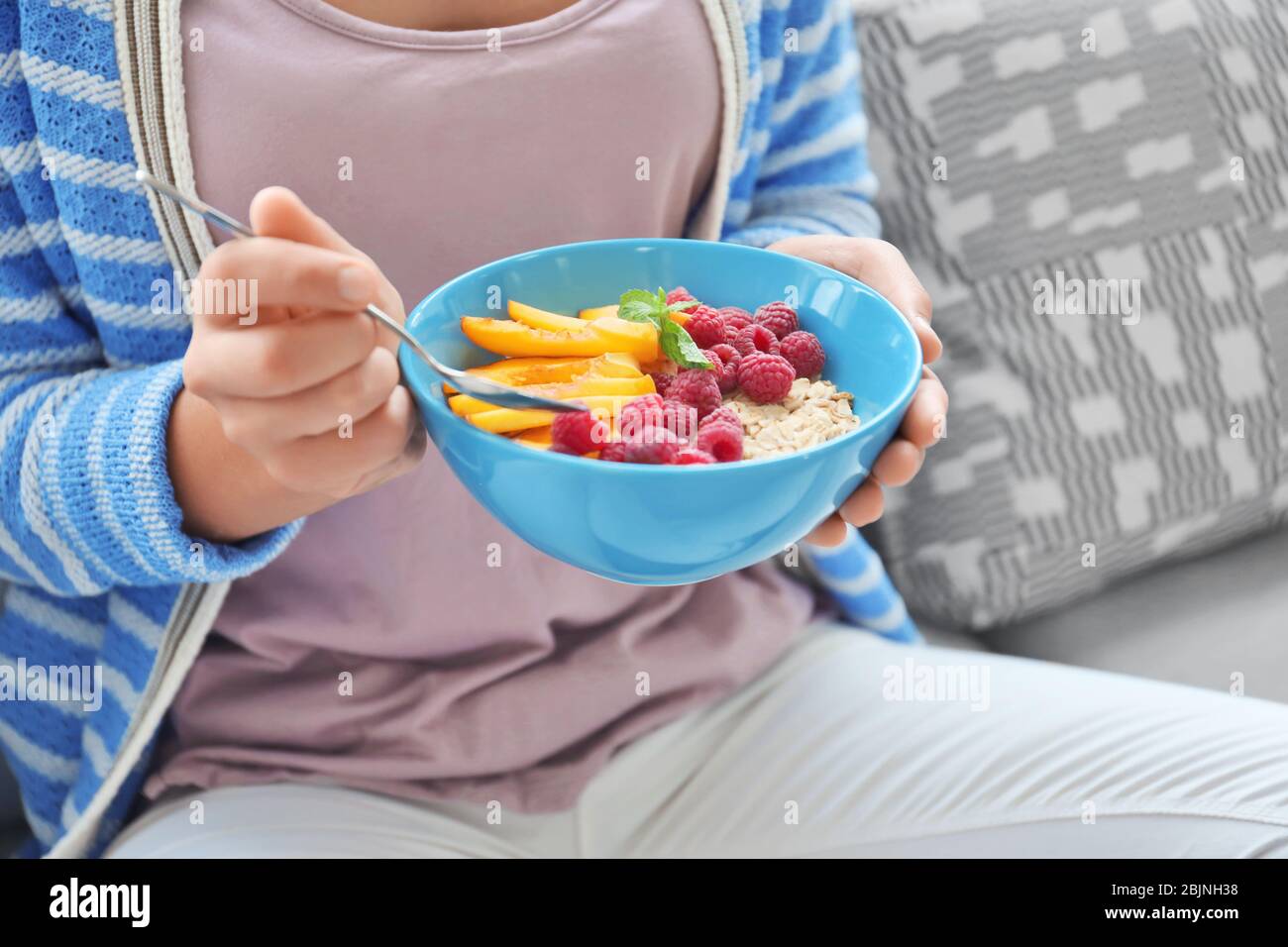 Woman eating oatmeal indoors Stock Photo - Alamy