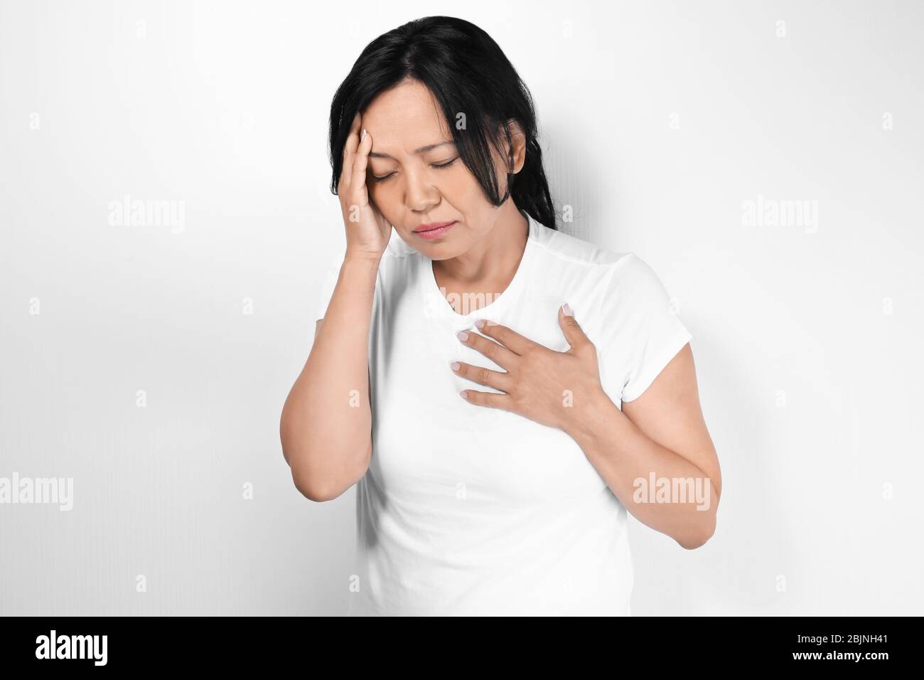 Mature woman suffering from pain on white background Stock Photo - Alamy