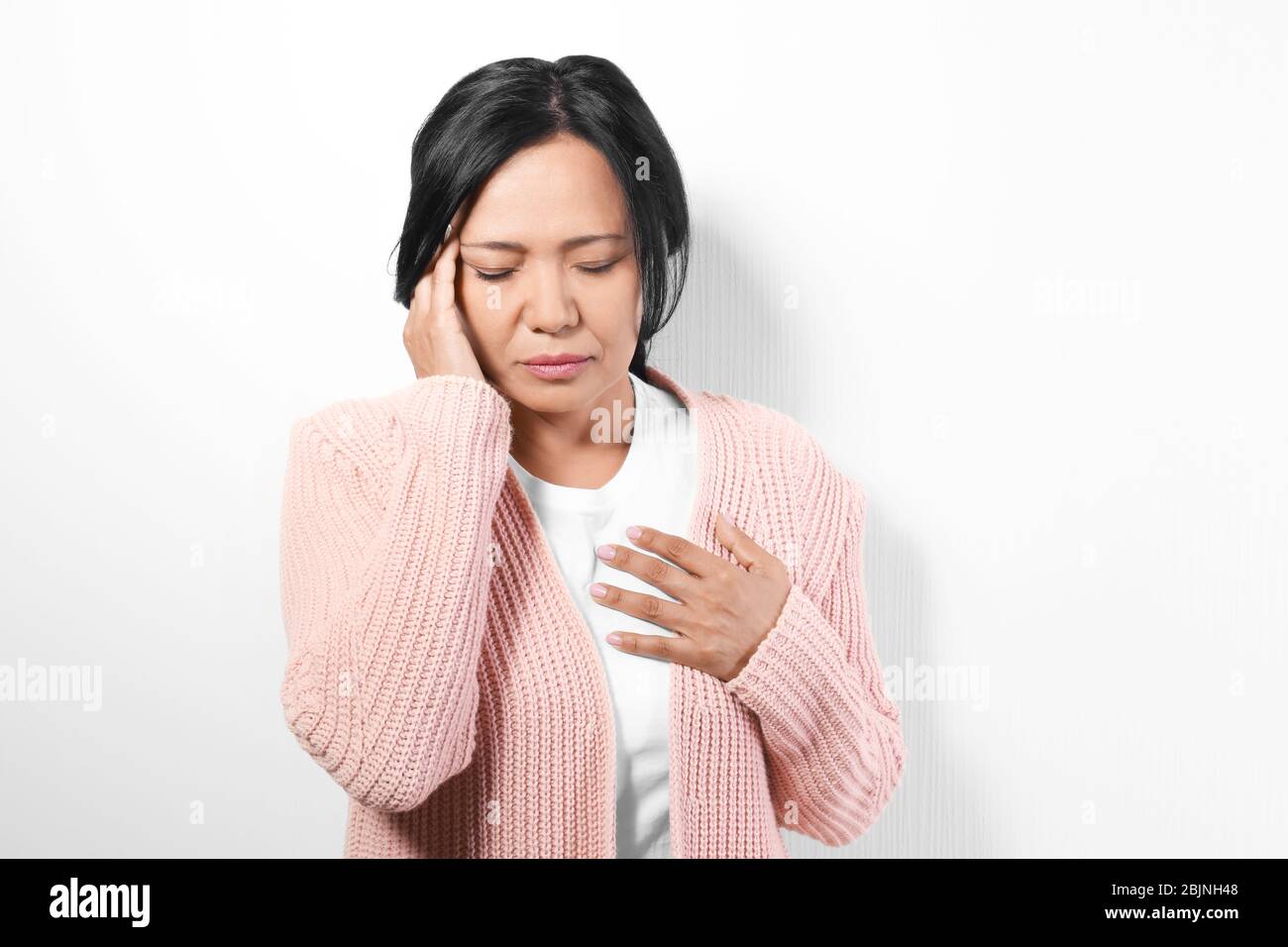 Mature woman suffering from pain on white background Stock Photo - Alamy