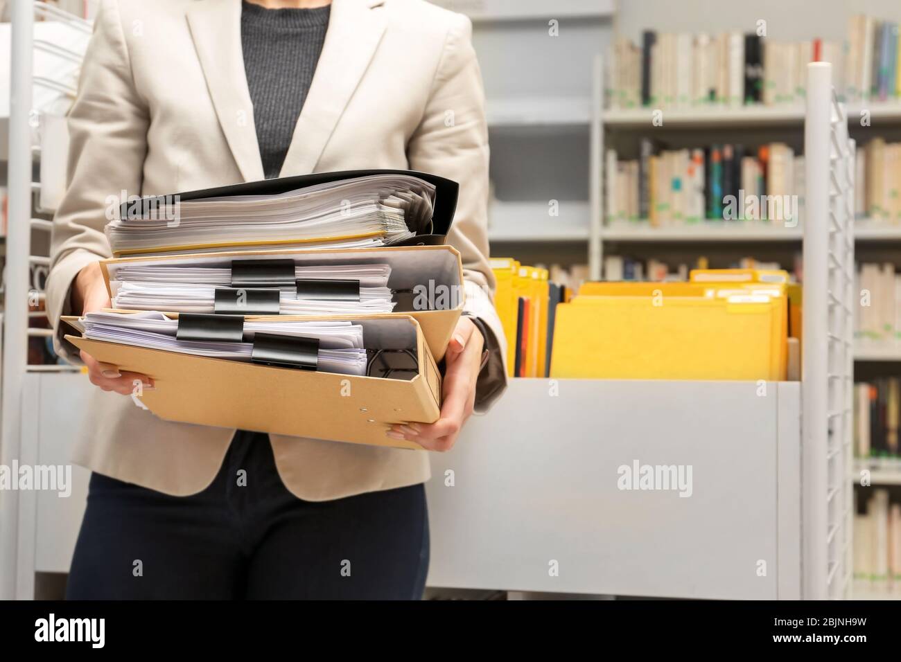 Woman searching for documents in archive Stock Photo - Alamy