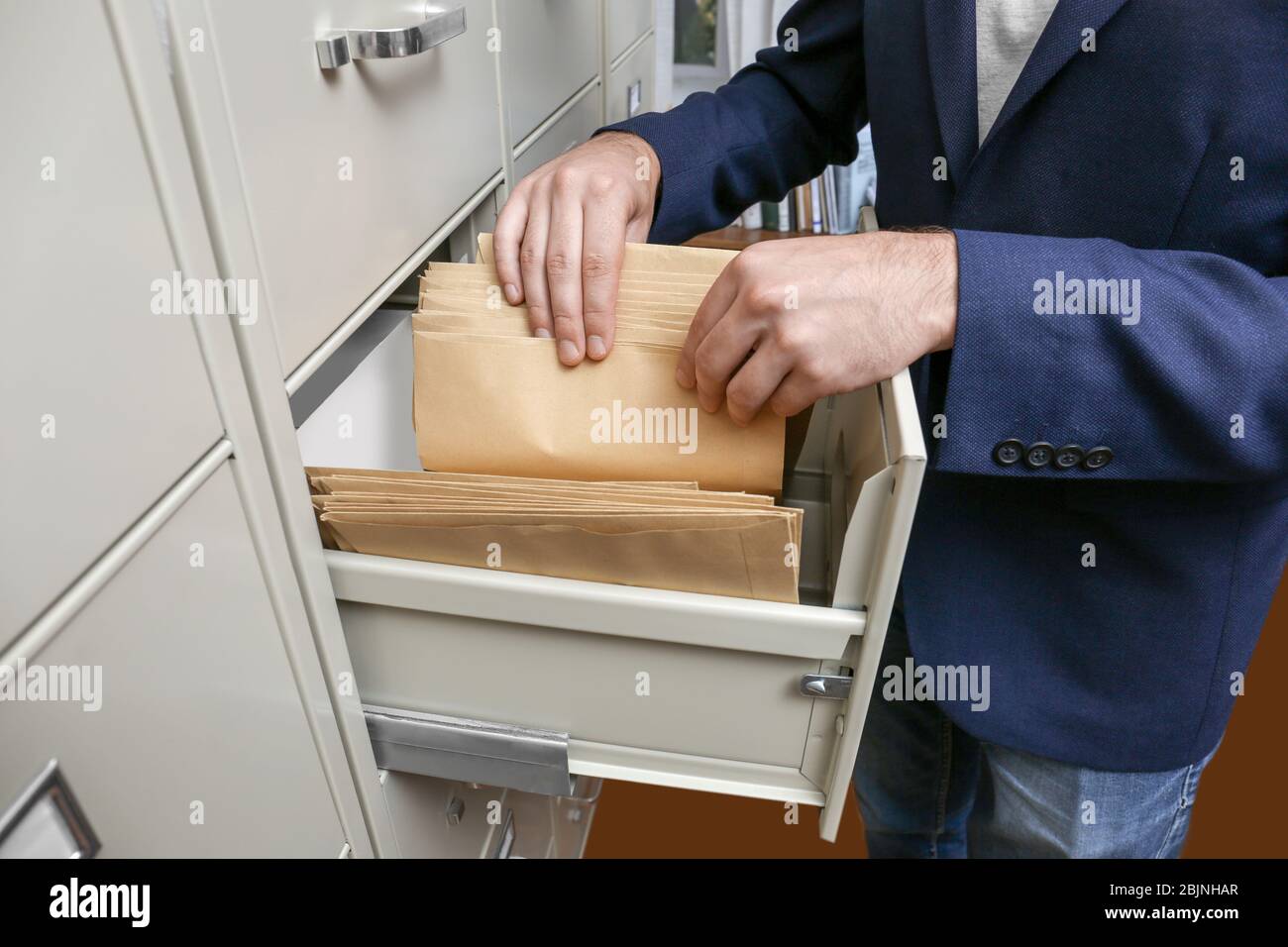 Man searching for documents in archive Stock Photo - Alamy