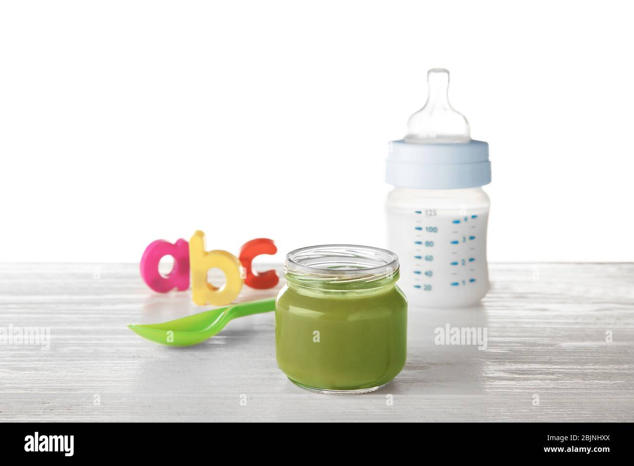 Composition with yummy baby food on wooden table against white ...