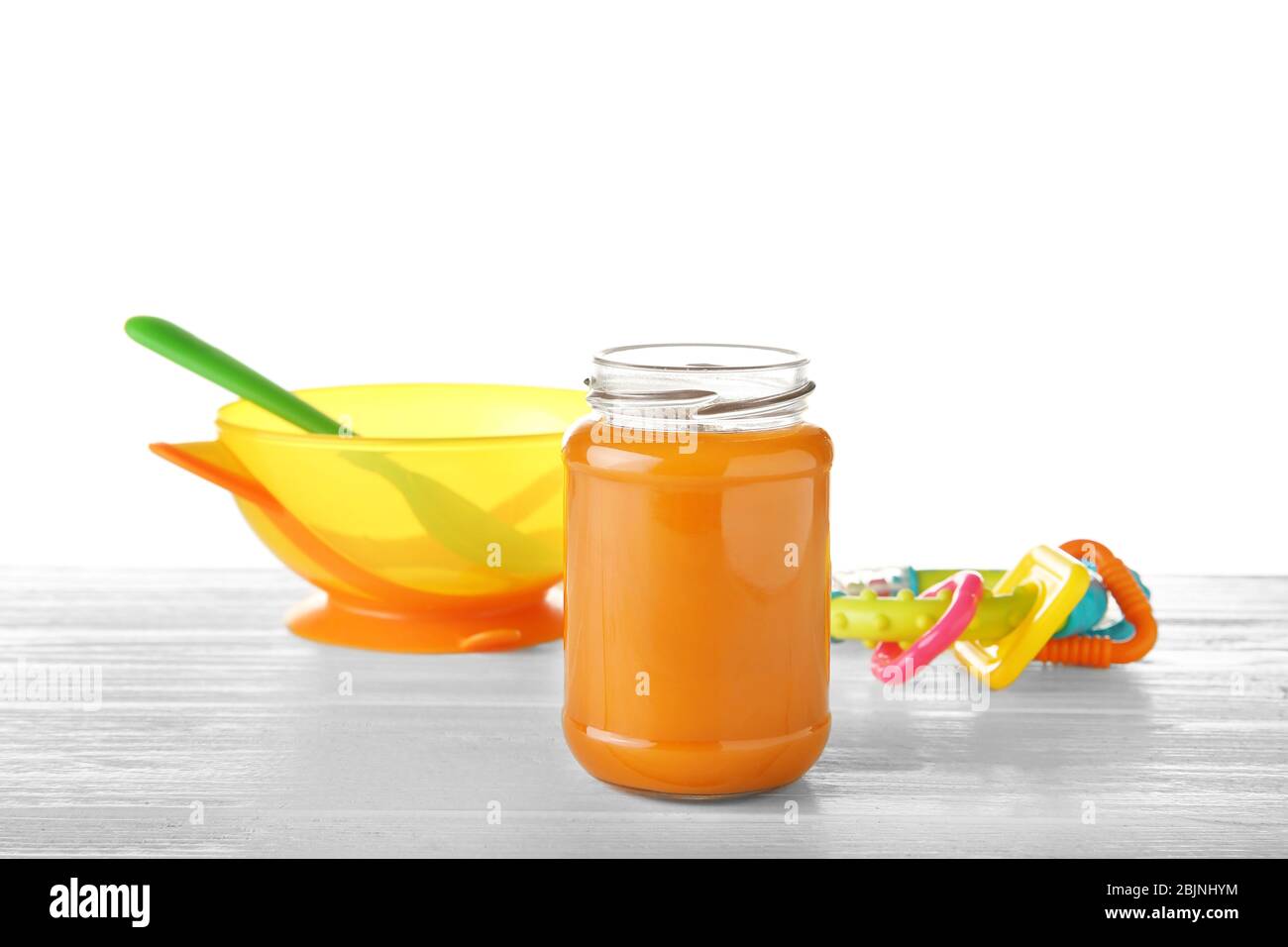 Composition with yummy baby food on wooden table against white ...