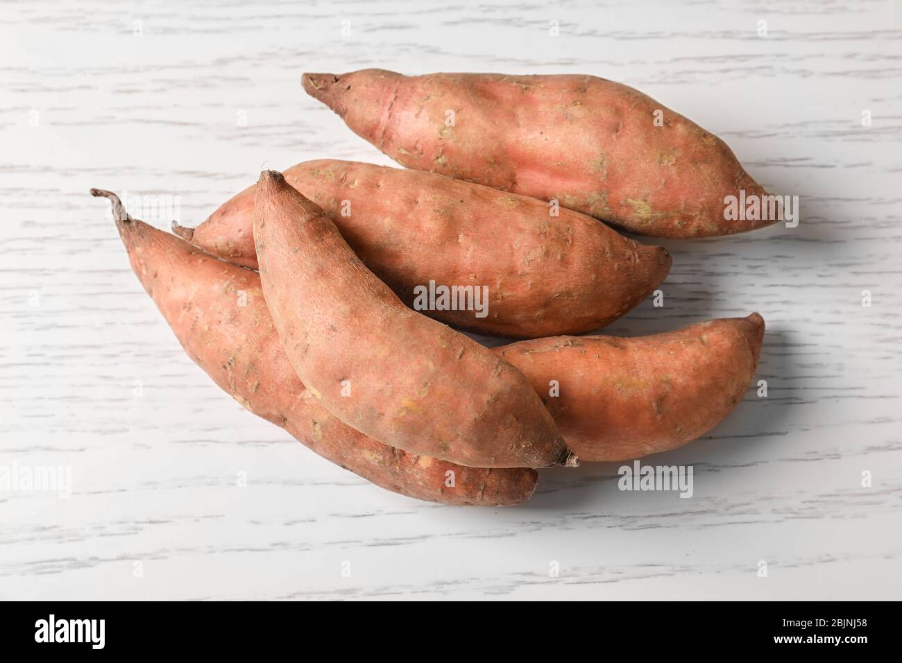 Sweet potatoes on light background Stock Photo - Alamy