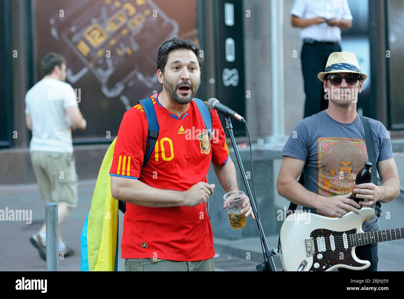 Drunk soccer Spanish fan wearing red T-shirt singing into the ...