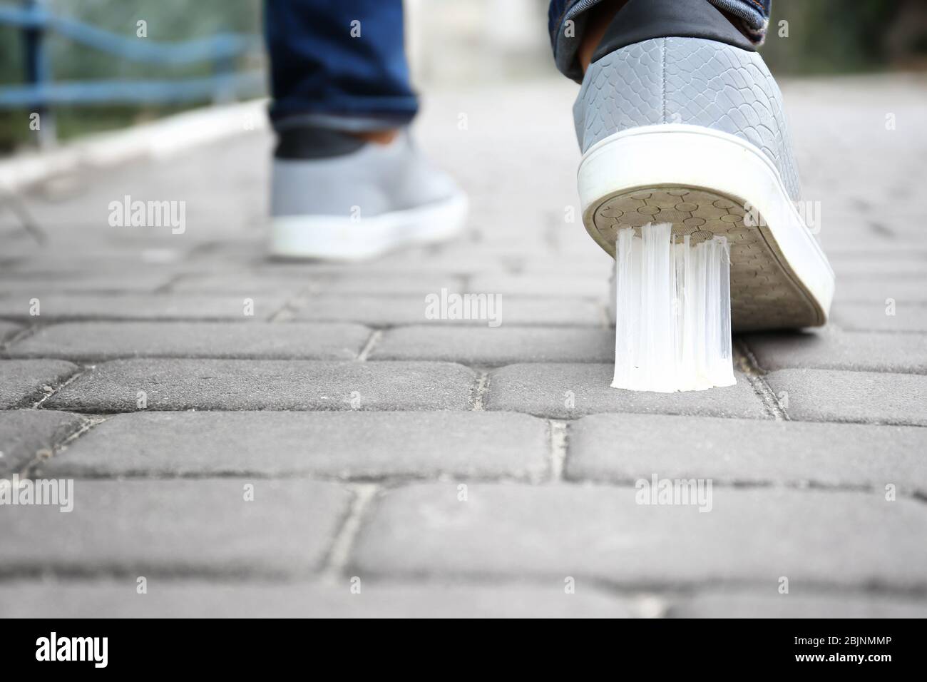 Foot stuck into chewing gum on street. Concept of stickiness Stock ...