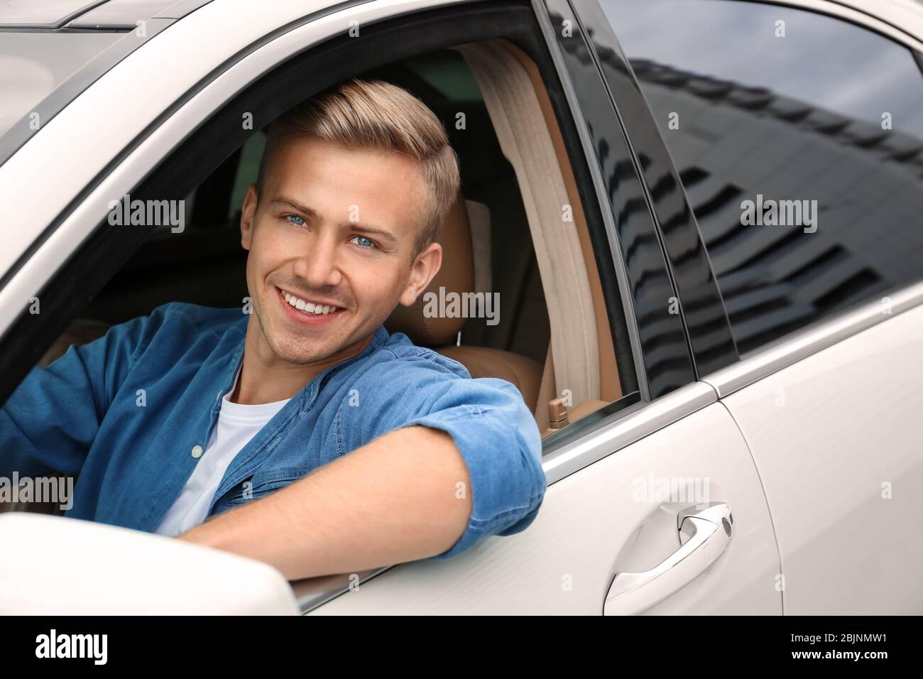 Young man on driver seat of car Stock Photo - Alamy