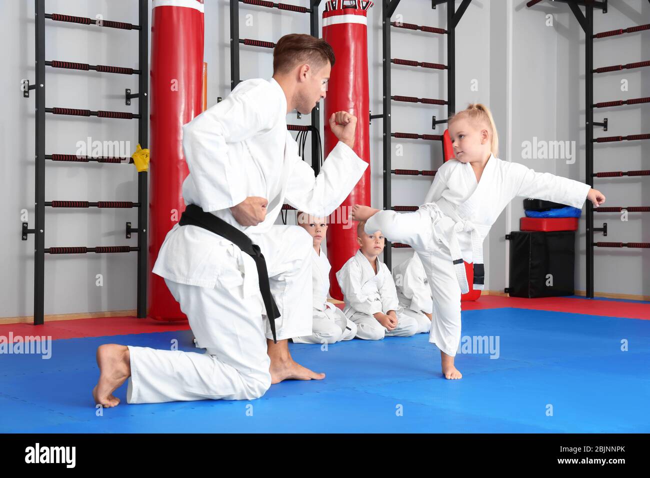 Male karate instructor training little children in dojo Stock Photo - Alamy