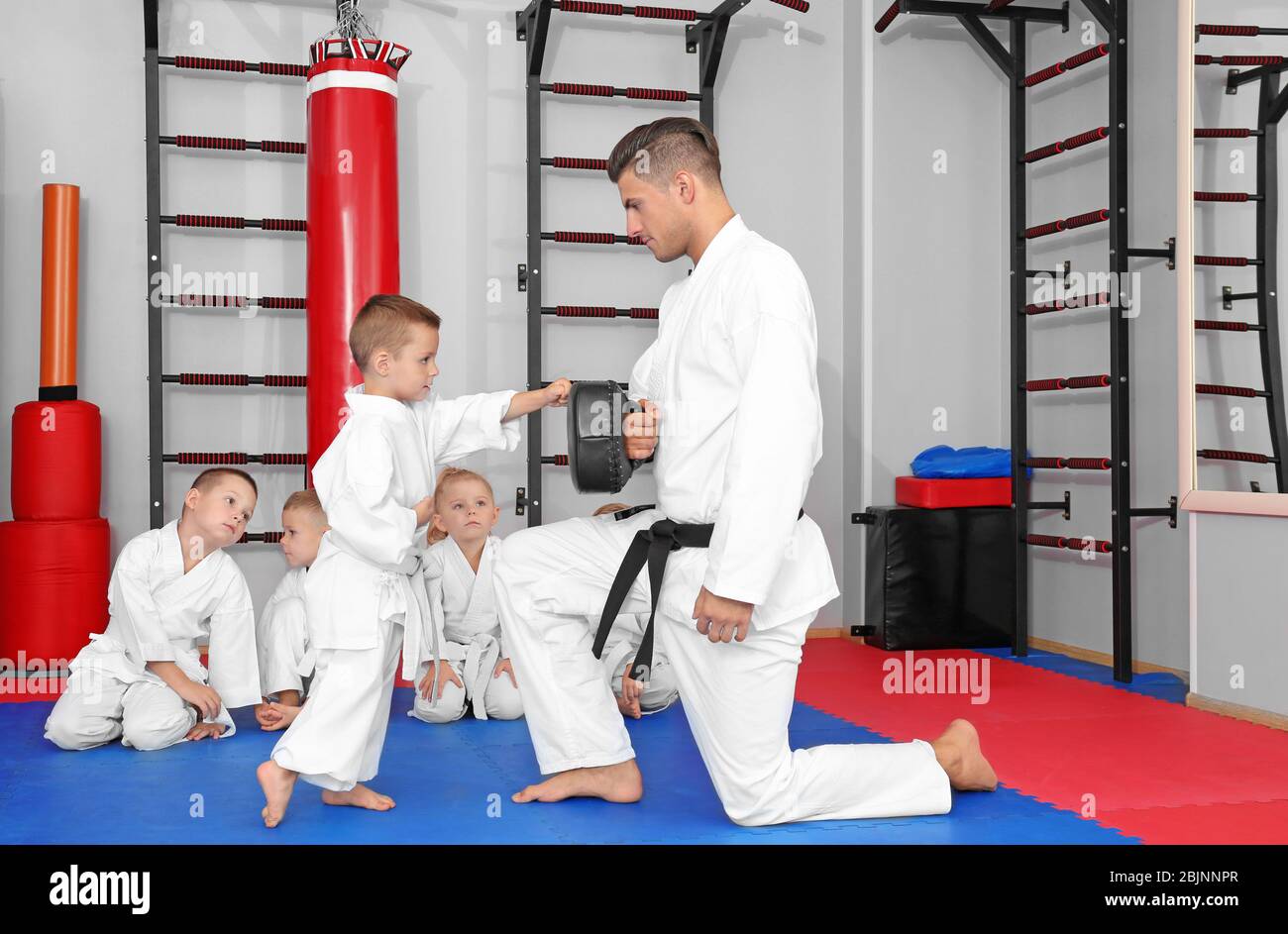 Male karate instructor training little boy in dojo Stock Photo - Alamy