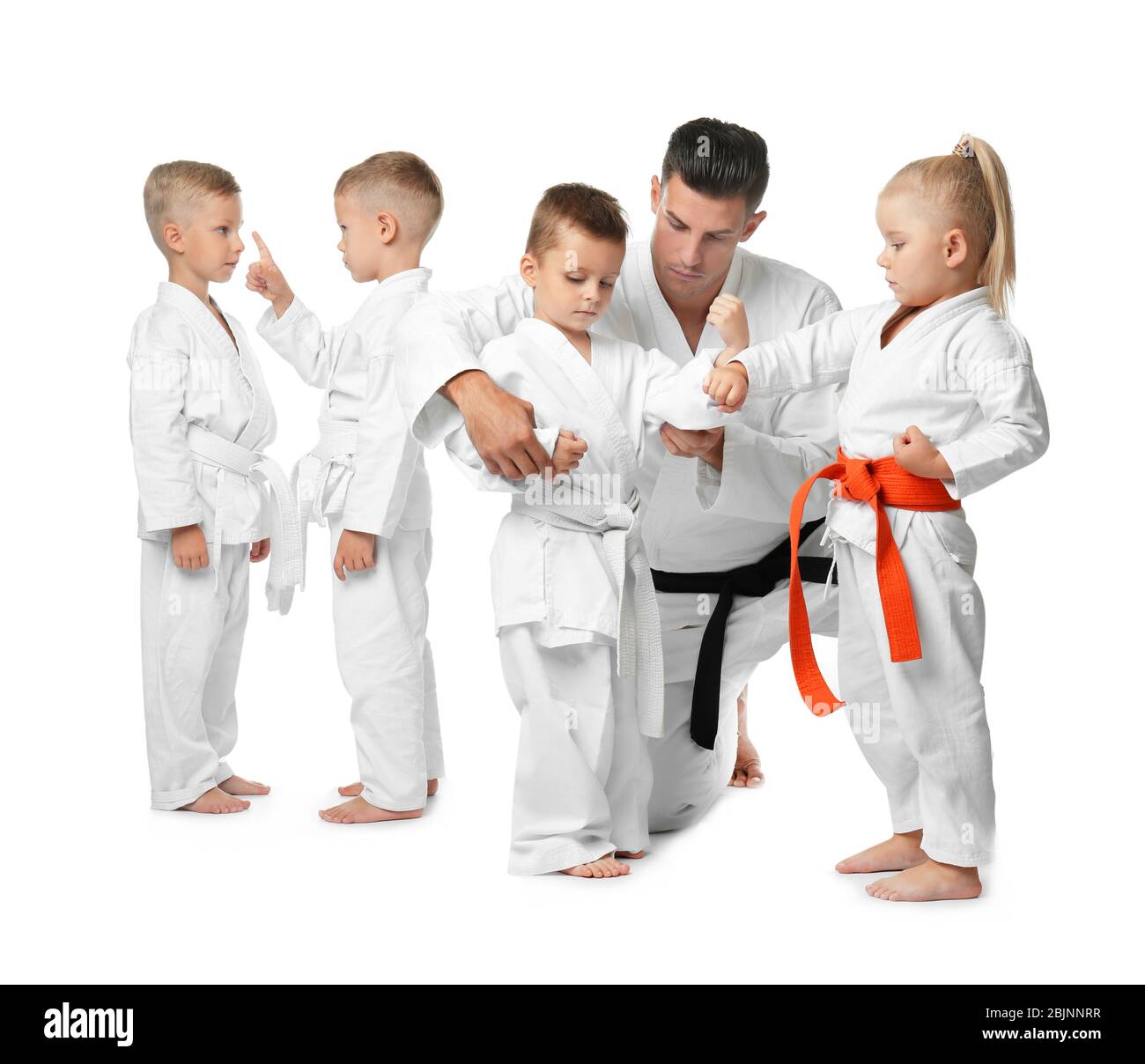 Little children with instructor practicing karate on white background ...