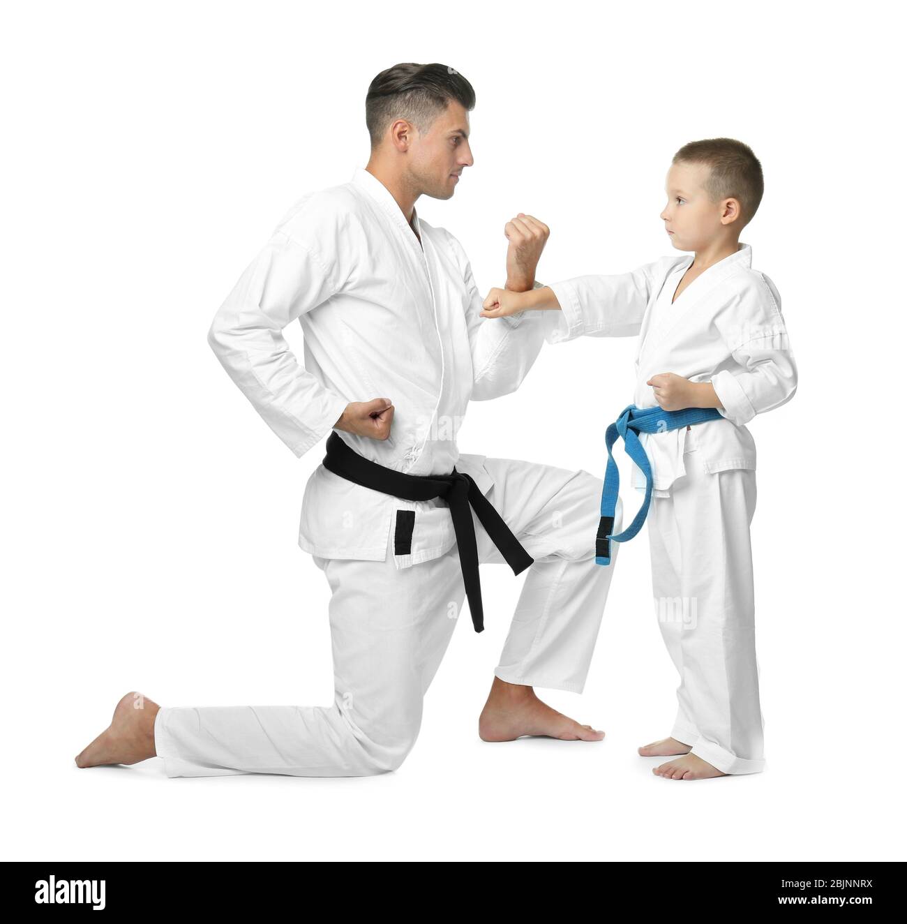 Little child with instructor practicing karate on white background ...