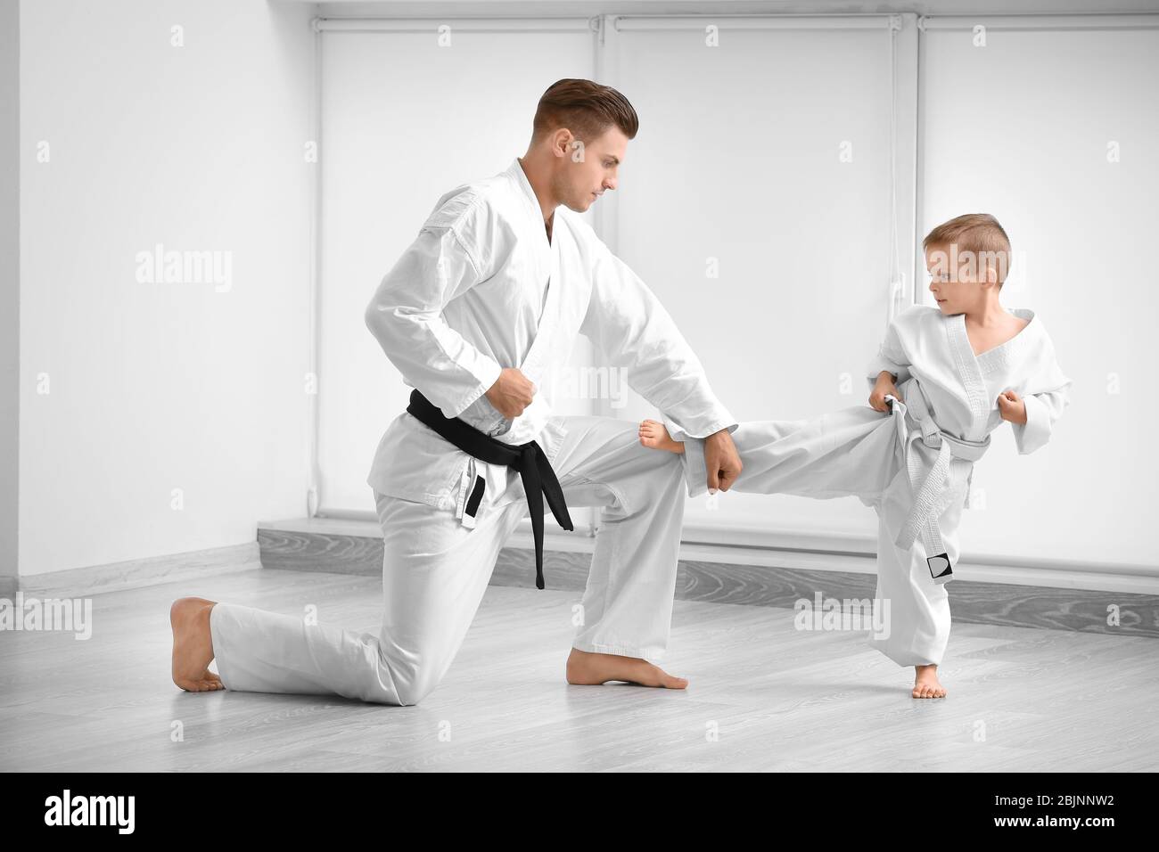 Little boy with instructor practicing karate in dojo Stock Photo - Alamy