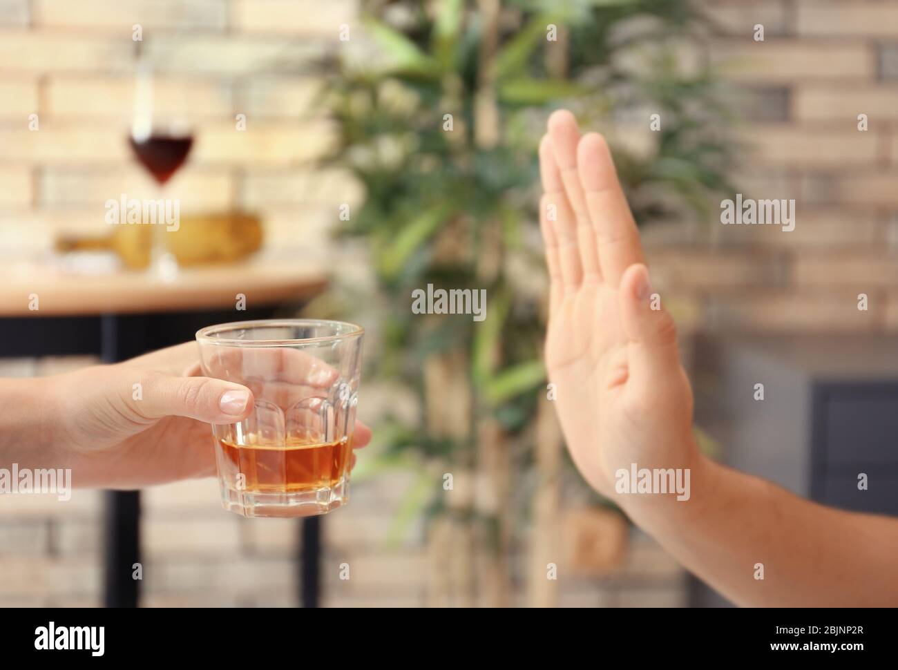 Hand of man refusing glass of alcohol indoors Stock Photo - Alamy
