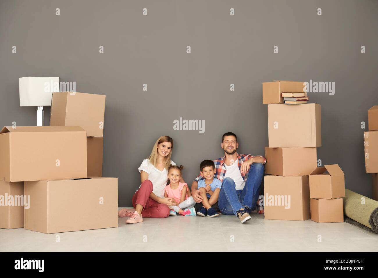 Happy family with cardboard boxes in new flat Stock Photo - Alamy