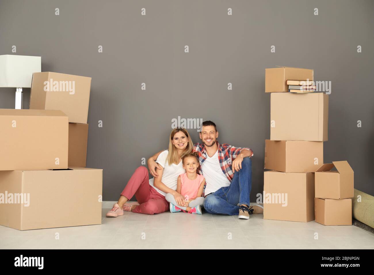 Happy family with cardboard boxes in new flat Stock Photo - Alamy