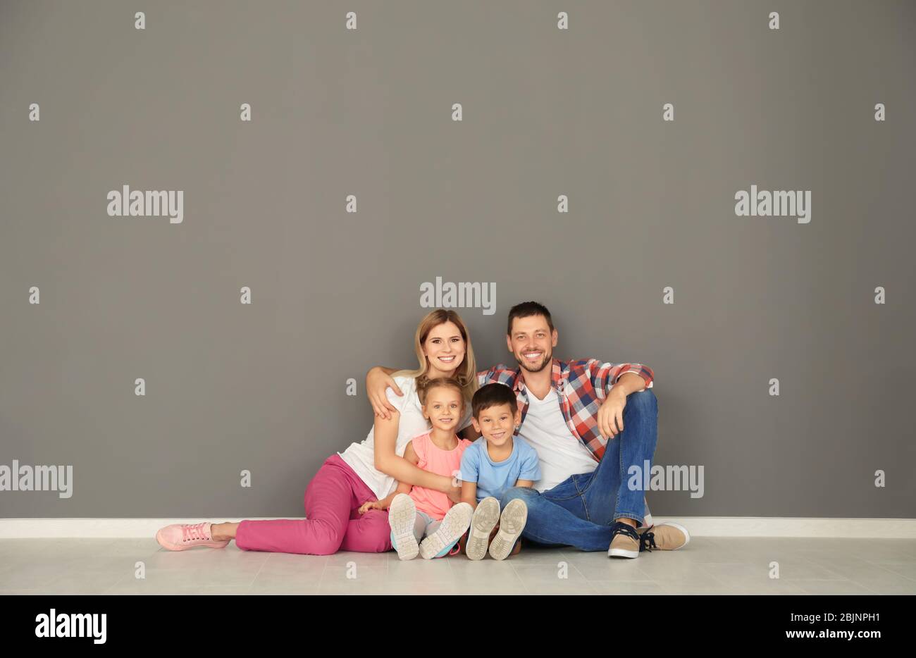 Happy family sitting on floor in new empty flat Stock Photo - Alamy