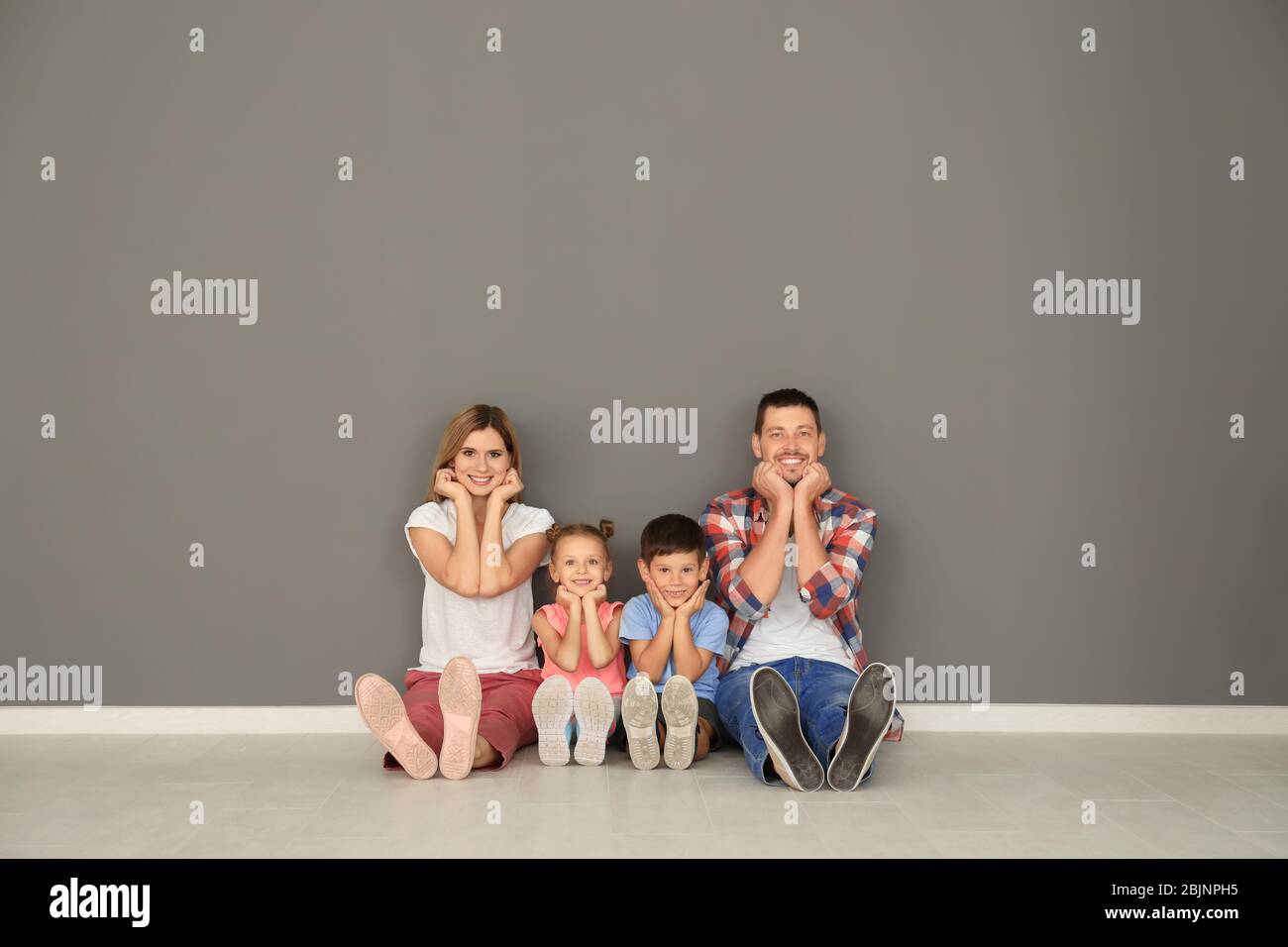 Happy family sitting on floor in new empty flat Stock Photo - Alamy
