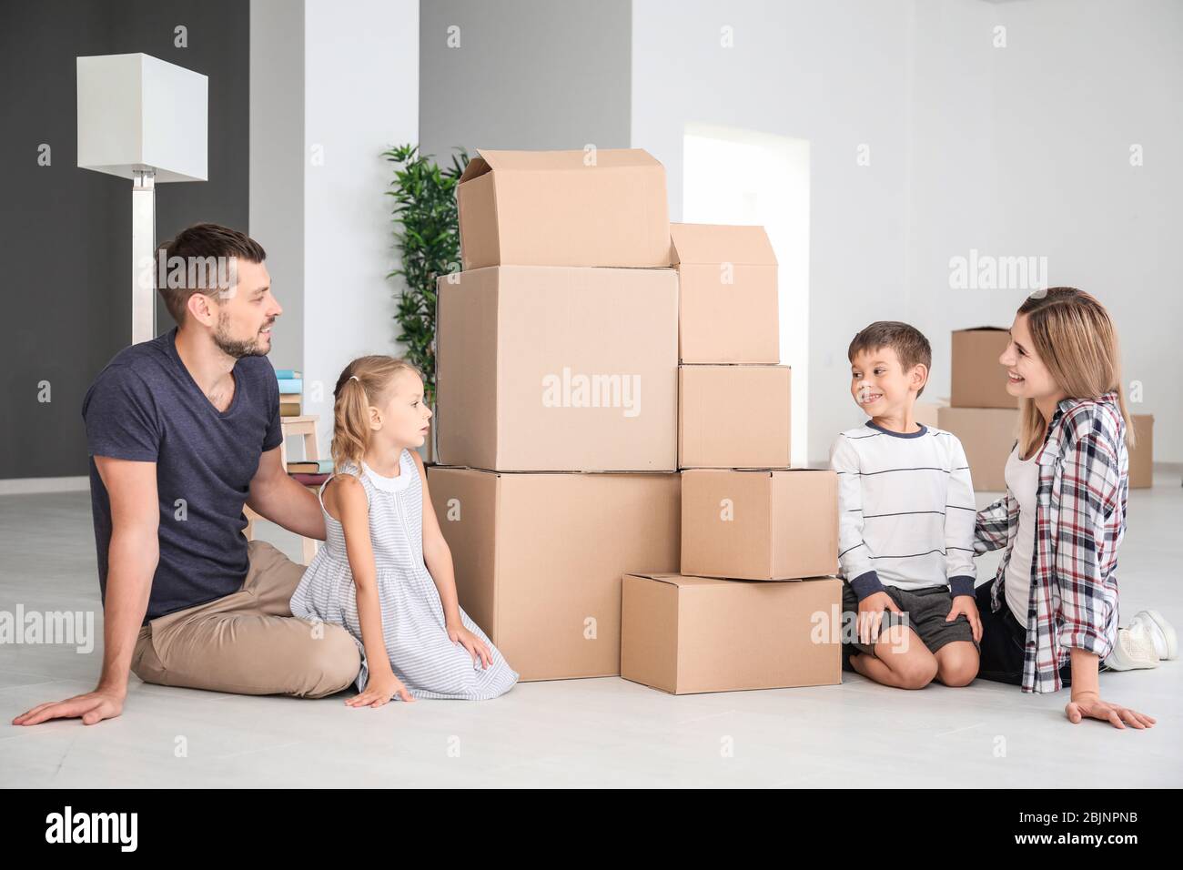 Happy family with cardboard boxes in new flat Stock Photo - Alamy